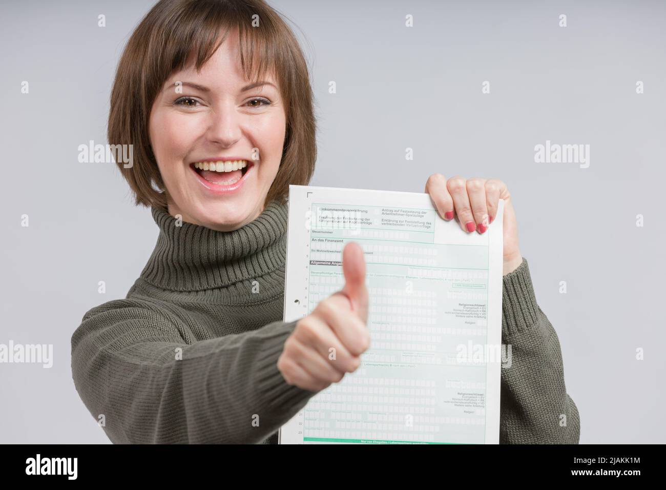 happy woman with a tax form shows thumbs-up Stock Photo - Alamy