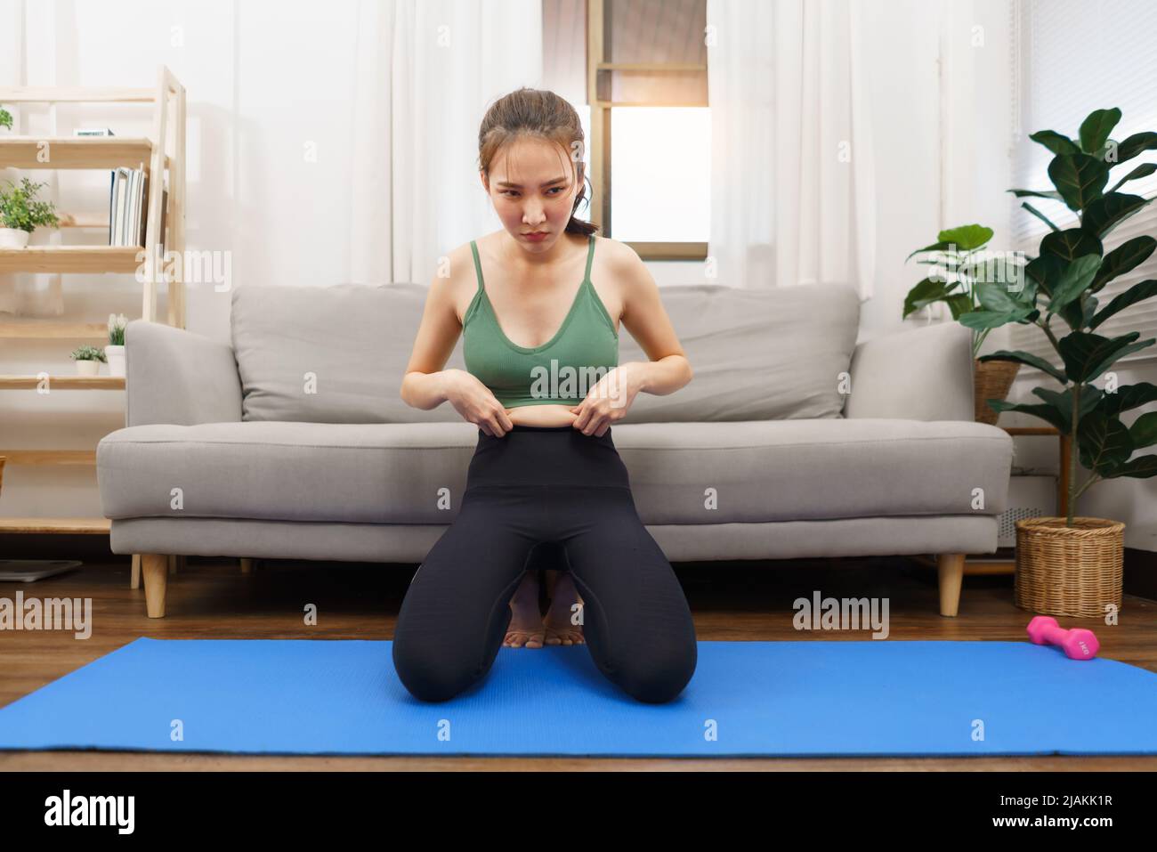 Healthy and weight loss concept, Young Asian woman use her hand to ...