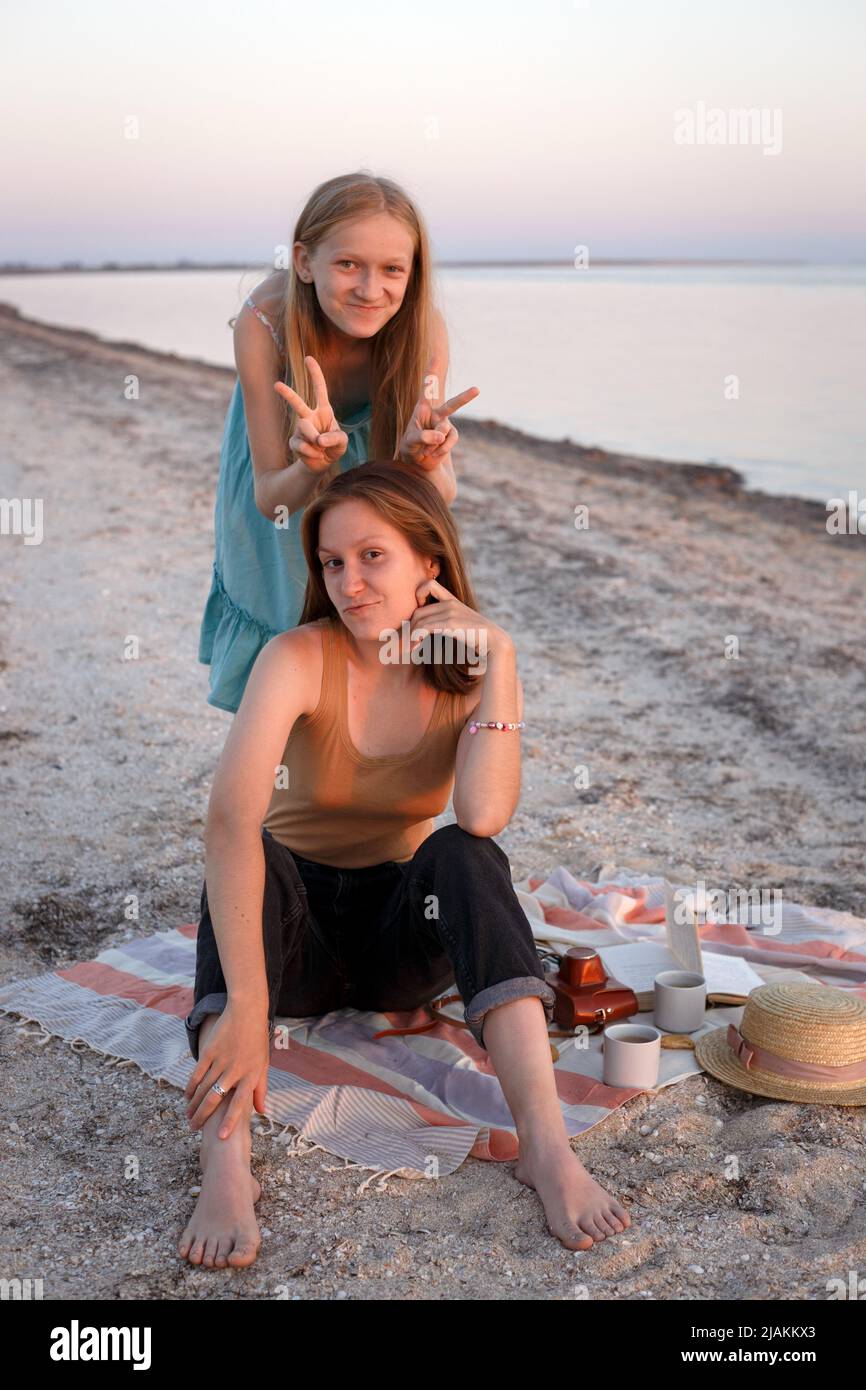 happy fun girl resting on the shore. sisters at a picnic Stock Photo ...
