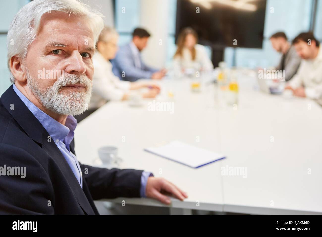Senior businessman as senior boss or manager at conference table with ...