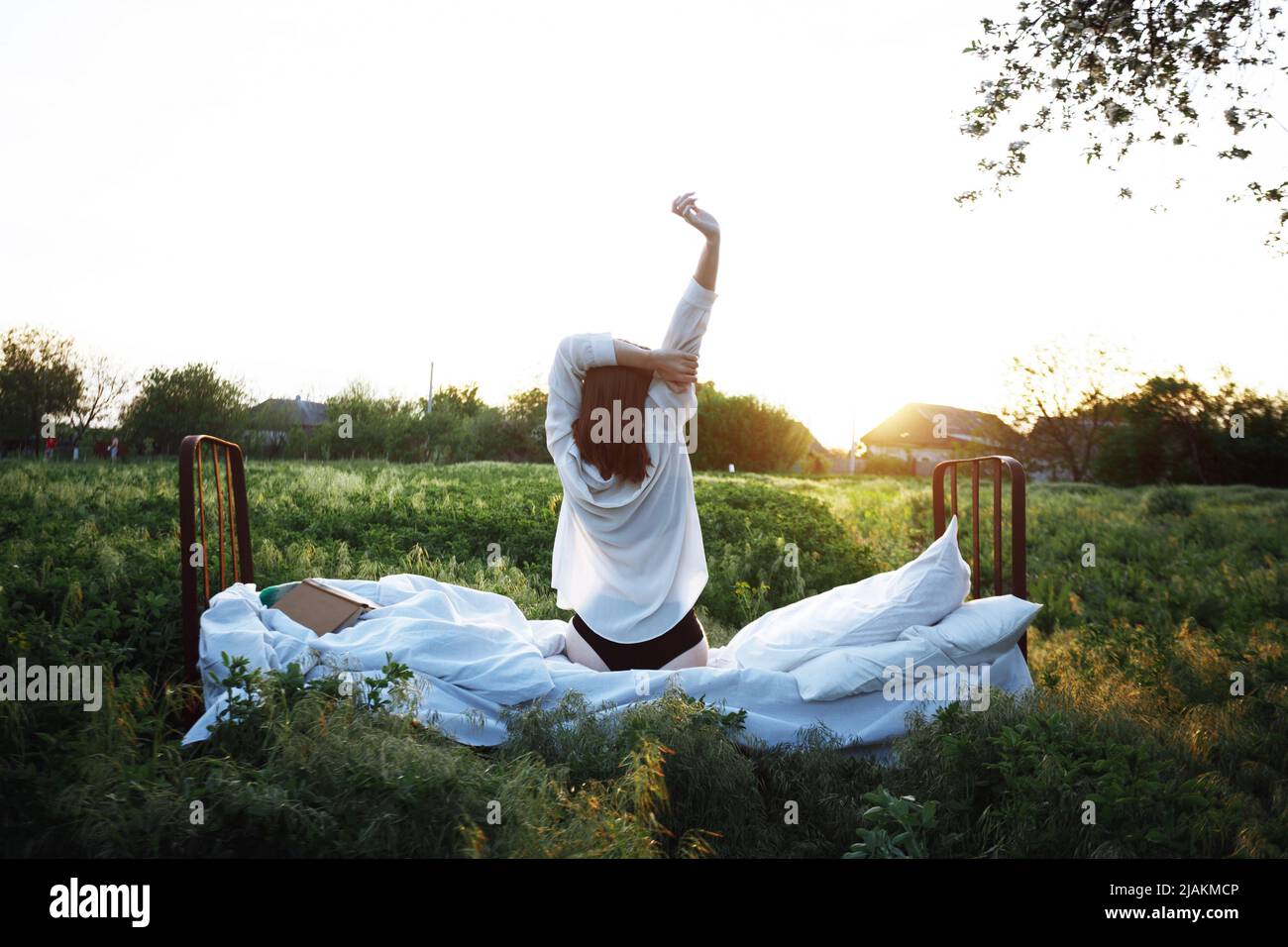 girl resting in the bed in a green field. healthy sleep in nature ...