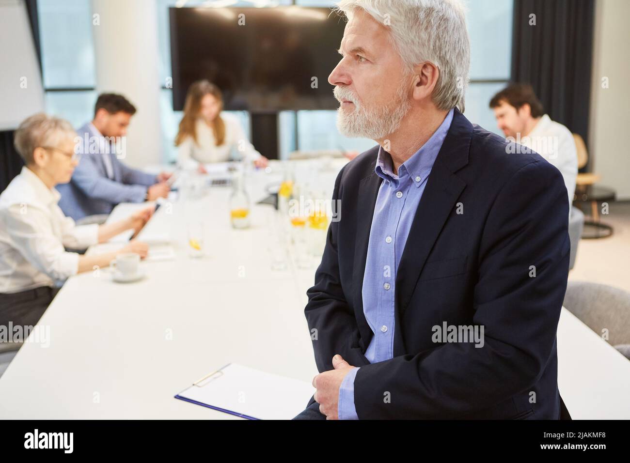Business man as businessman and boss with team at conference table in ...
