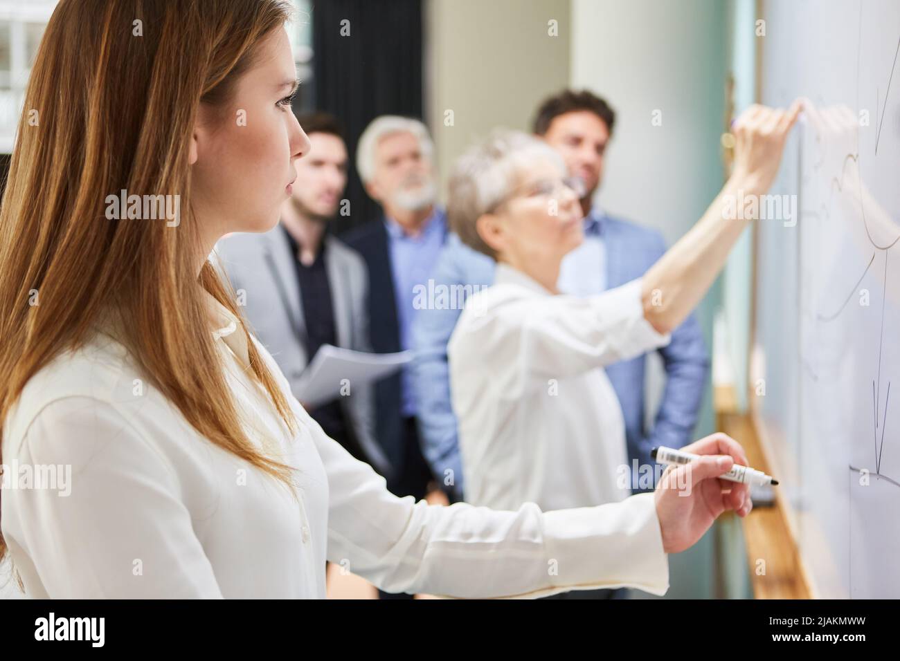 Young business woman as a trainee at the whiteboard in an ideas ...