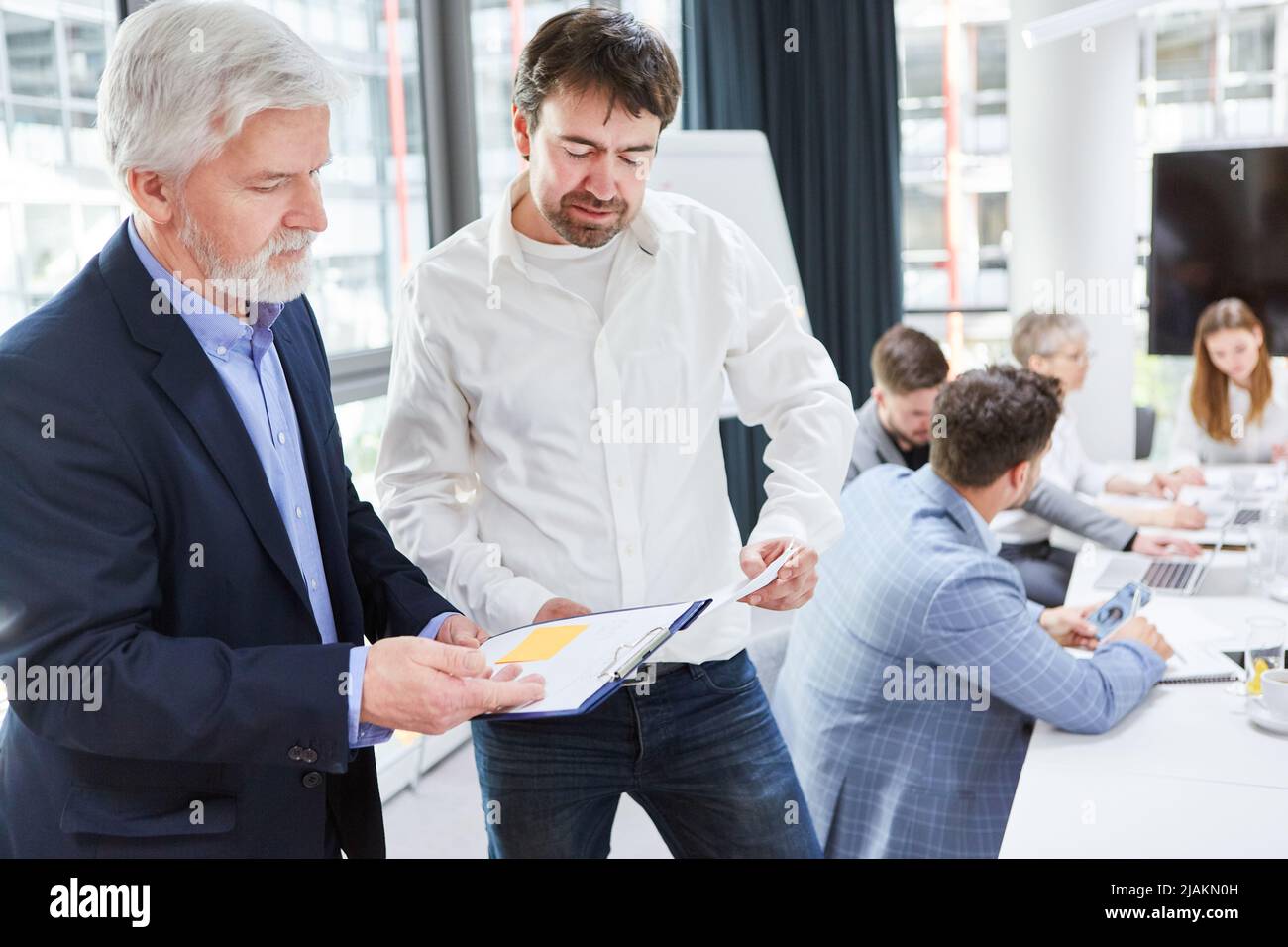 Senior boss and business man checking checklist on clipboard together ...