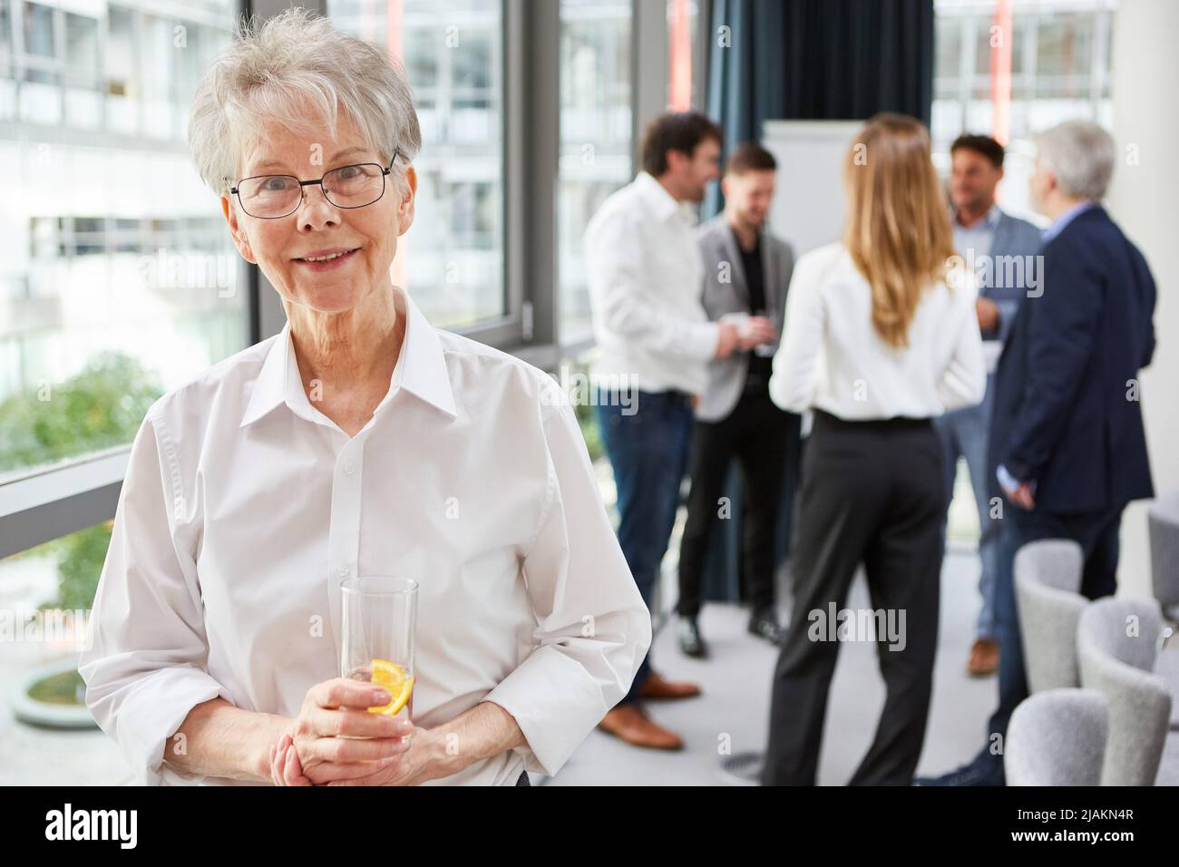 Senior business woman as boss on a break in office with team in ...