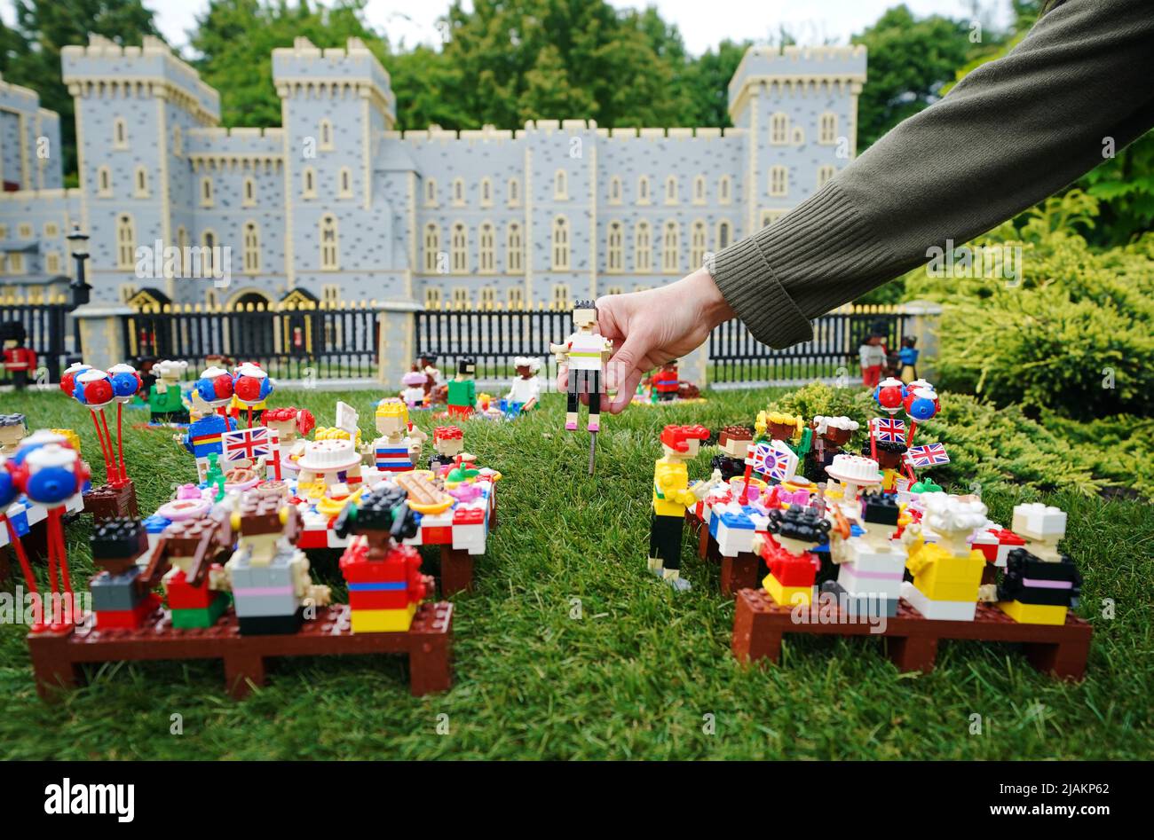 A member of the LEGOLAND Windsor staff places a LEGO figure into a ...