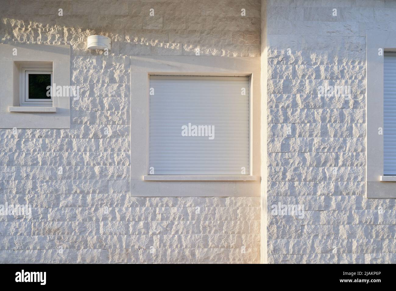Window roller shutter on a stone finished wall in a modern house Stock ...