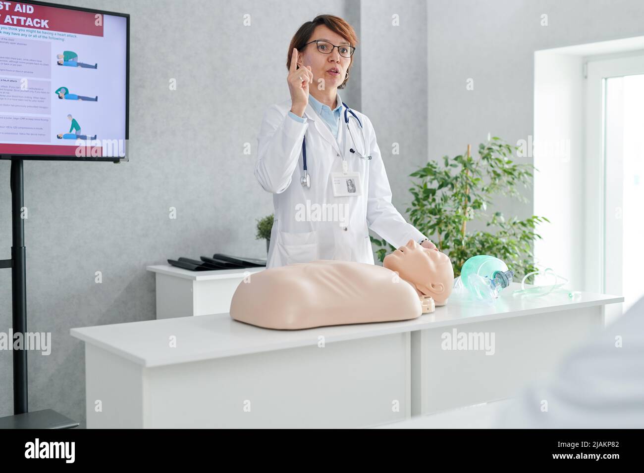 Mature female doctor talking about the rules of first aid using ...