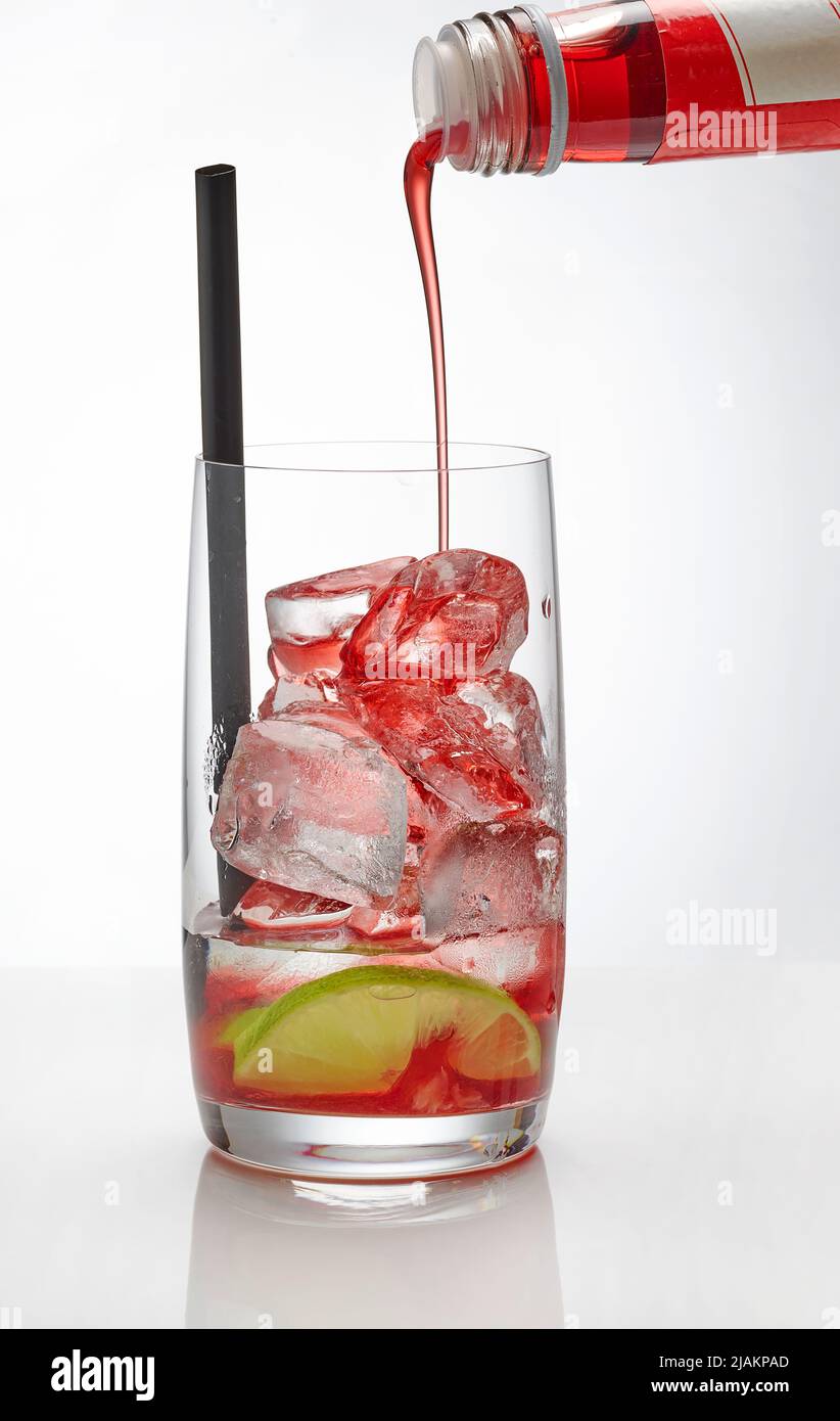 red syrup pouring into glass of ice Stock Photo - Alamy