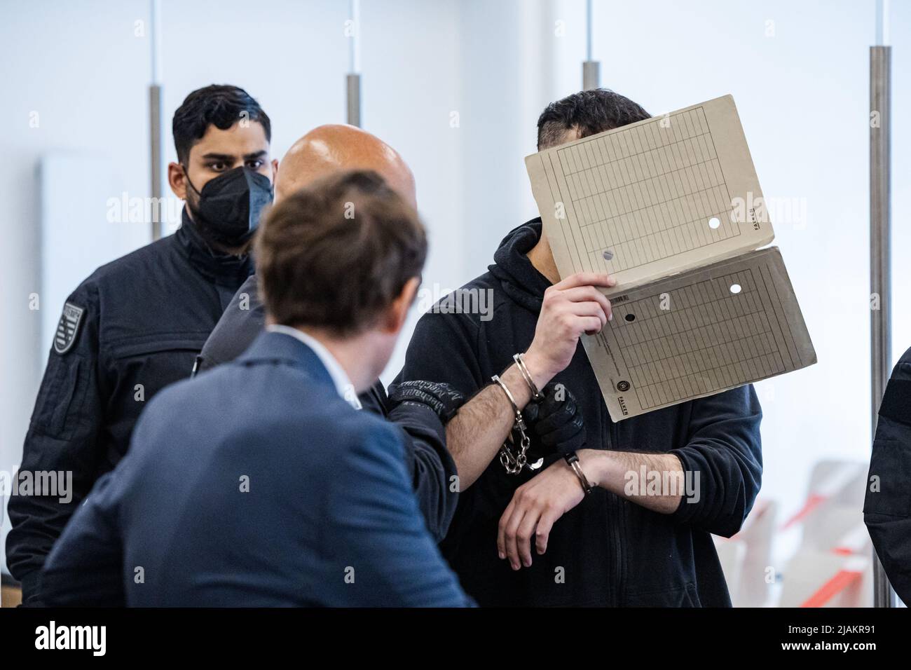 Dresden, Germany. 31st May, 2022. The defendant covers his face as he ...