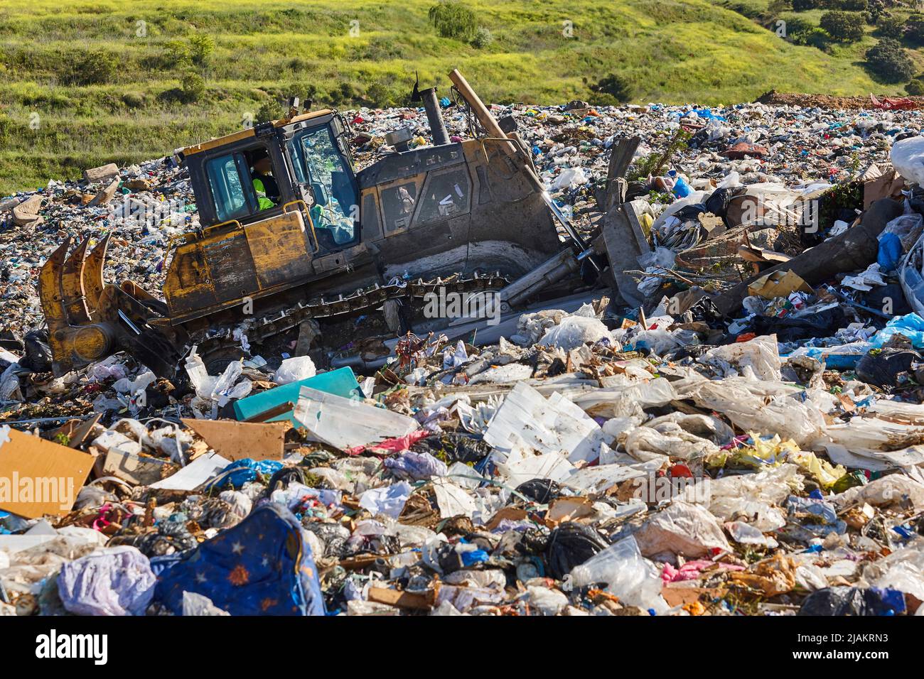 Heavy machinery shredding garbage in an open air landfill. Waste Stock ...