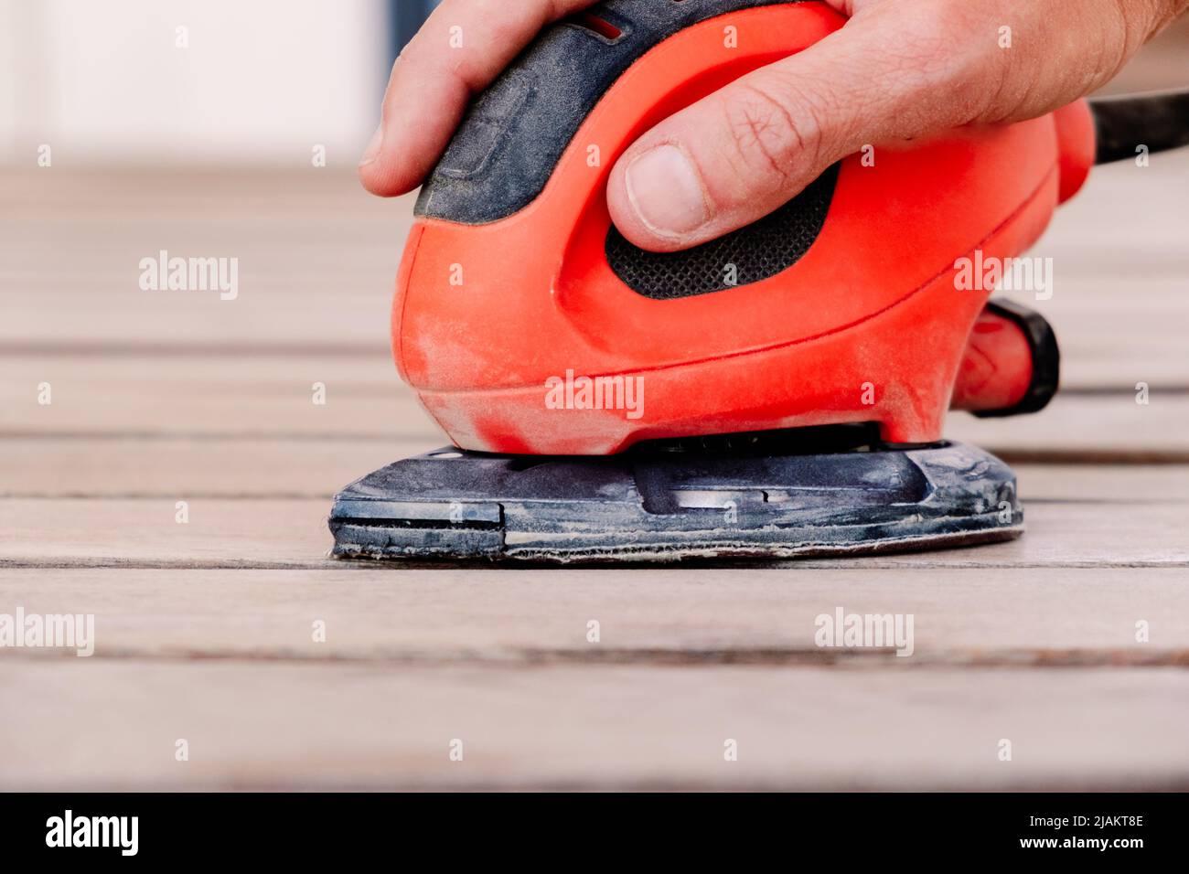 A hand held wood sander held by a woman Stock Photo - Alamy