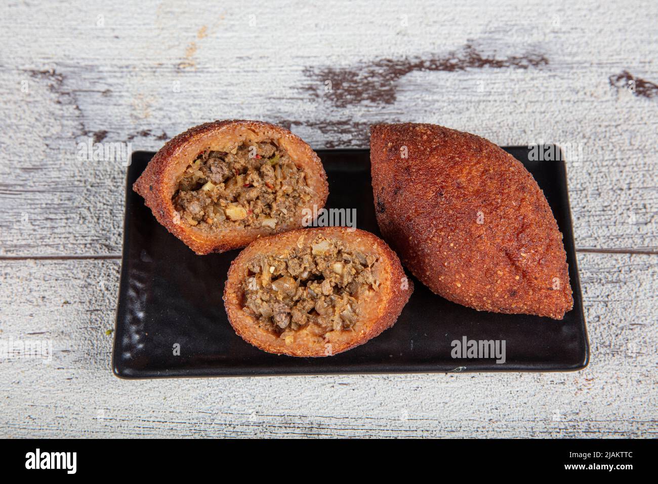 Kibbeh on a white wood background. Kibbeh is a popular dish in Middle ...
