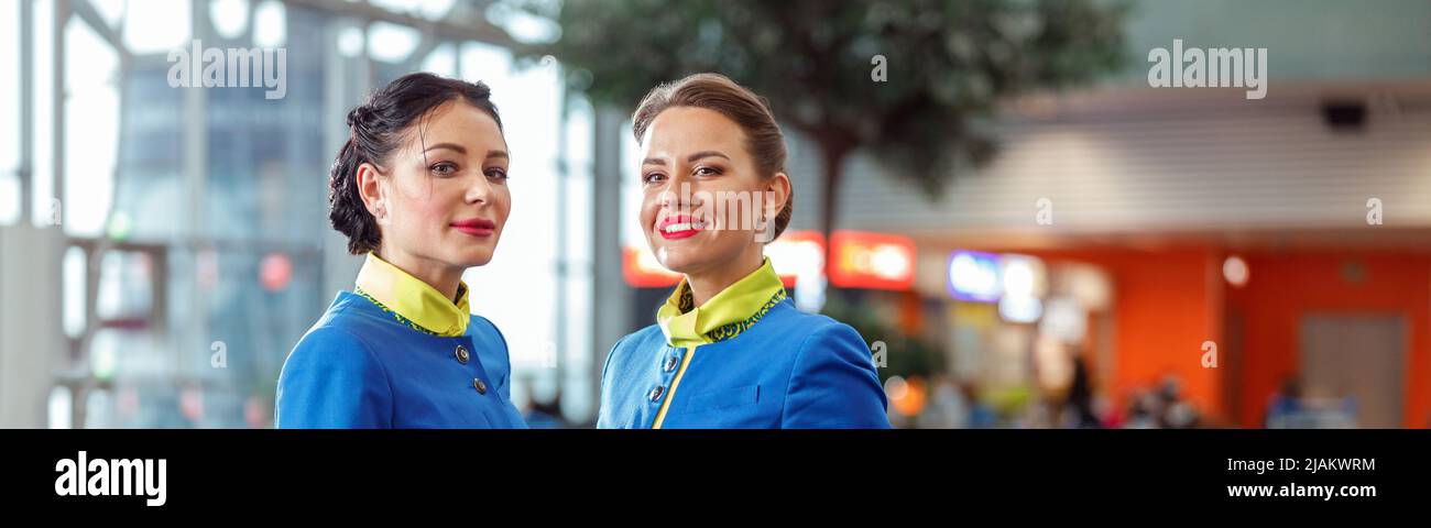 Two female flight attendants standing in airport terminal Stock Photo ...