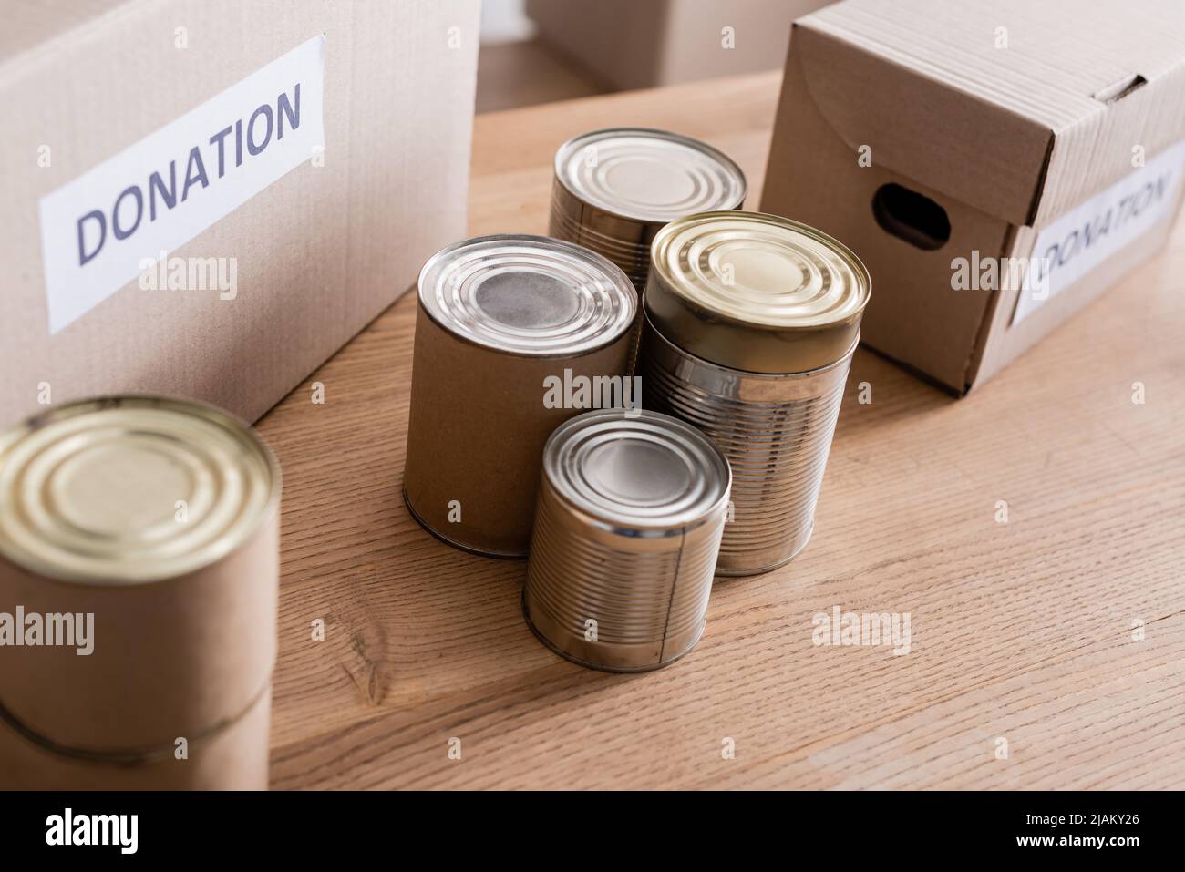 Canned food near boxes with donation lettering on table Stock Photo - Alamy