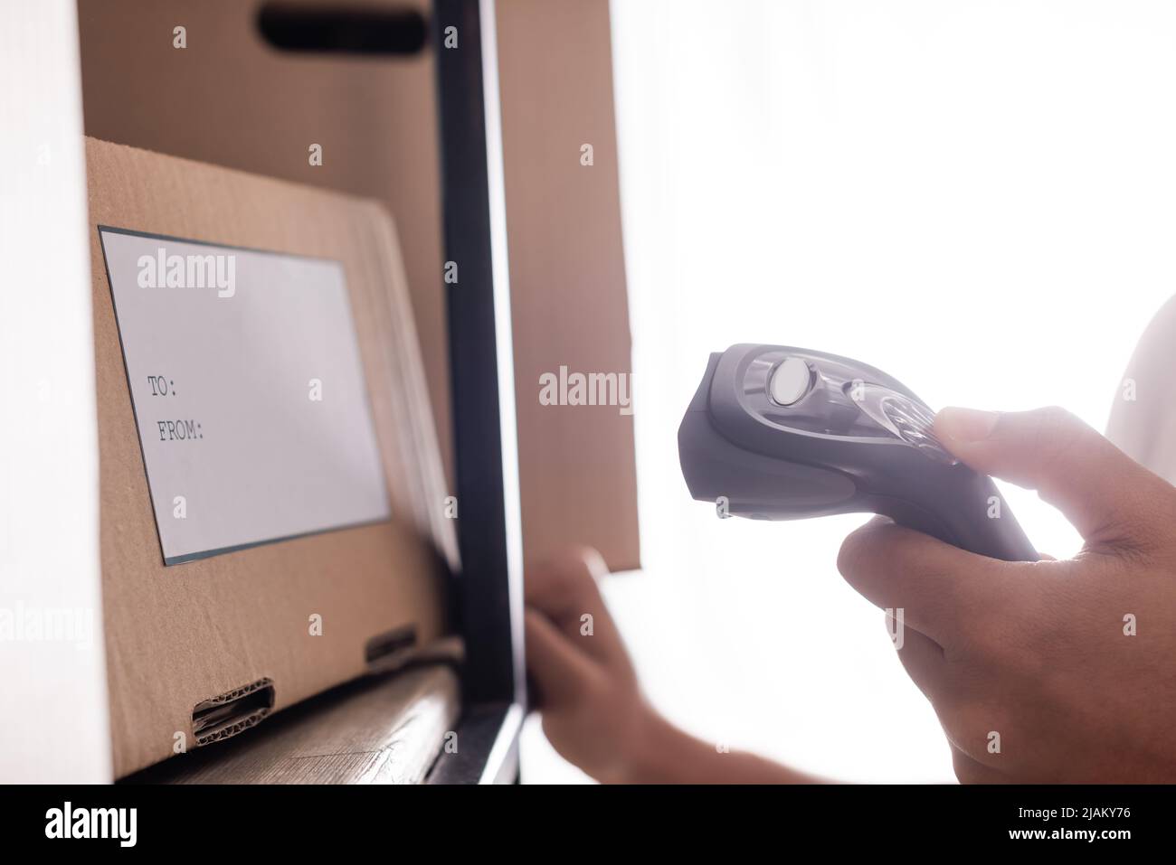 Cropped view of african american proprietor scanning box with shipping ...