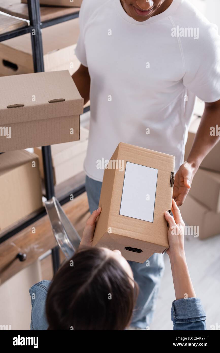 Overhead view of multiethnic sellers holding package with shipping ...