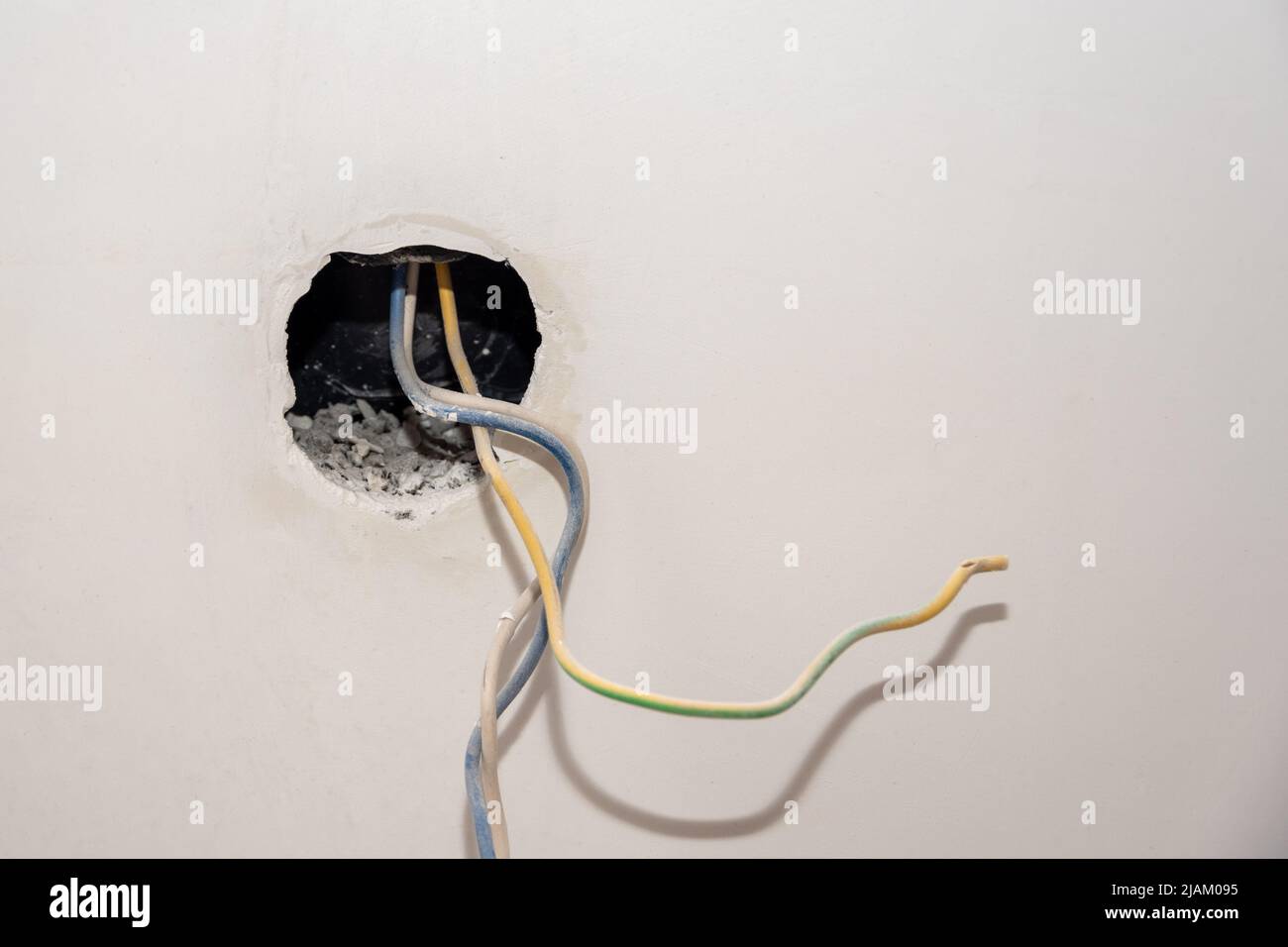 Hole in the wall with cables. Installation of new sockets, switches ...