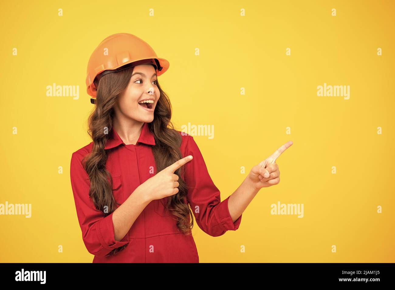 happy kid girl in protective helmet pointing finger on copy space for ...