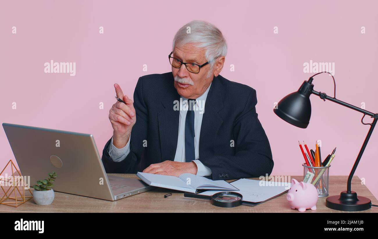 Thoughtful senior businessman making notes, writing down thoughts with ...