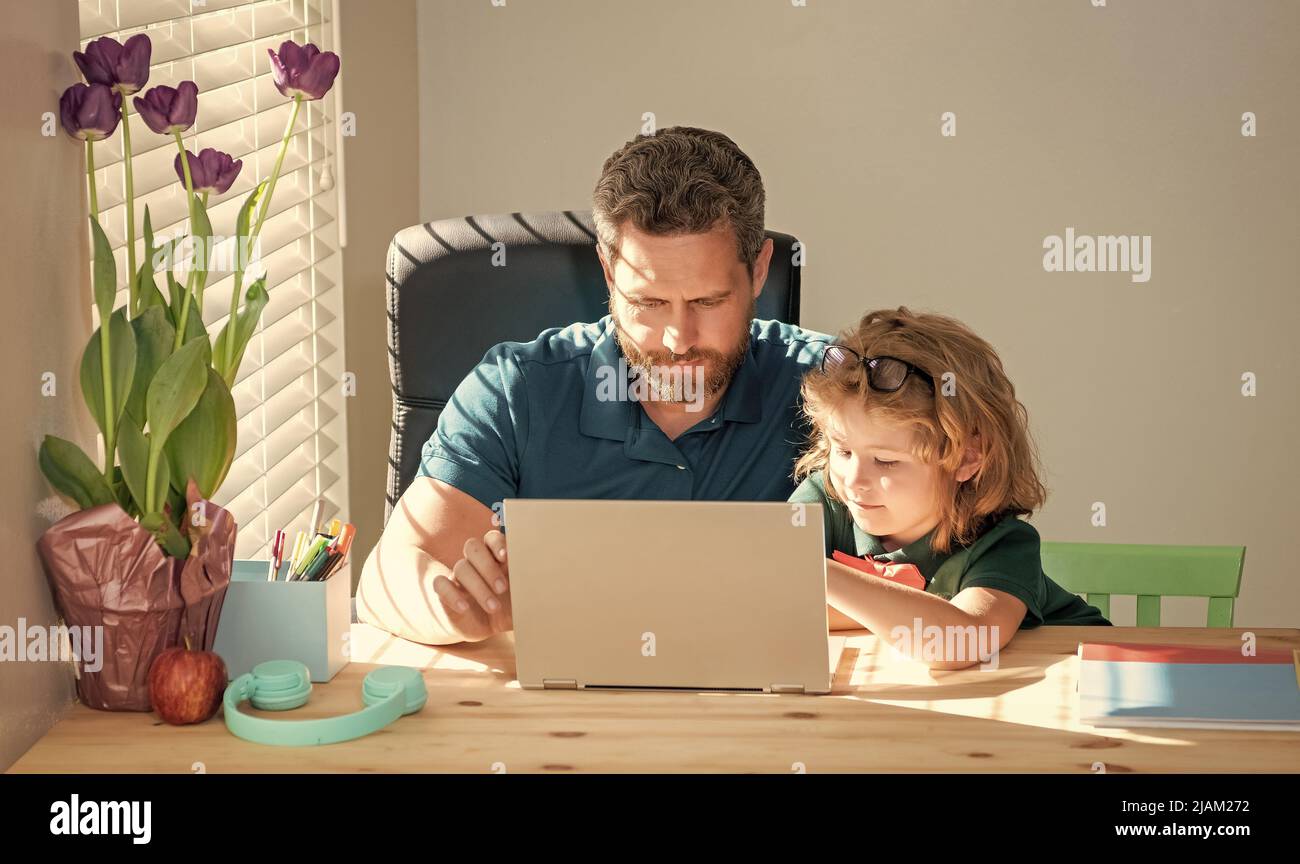 attentive father and child son at school working online on laptop ...