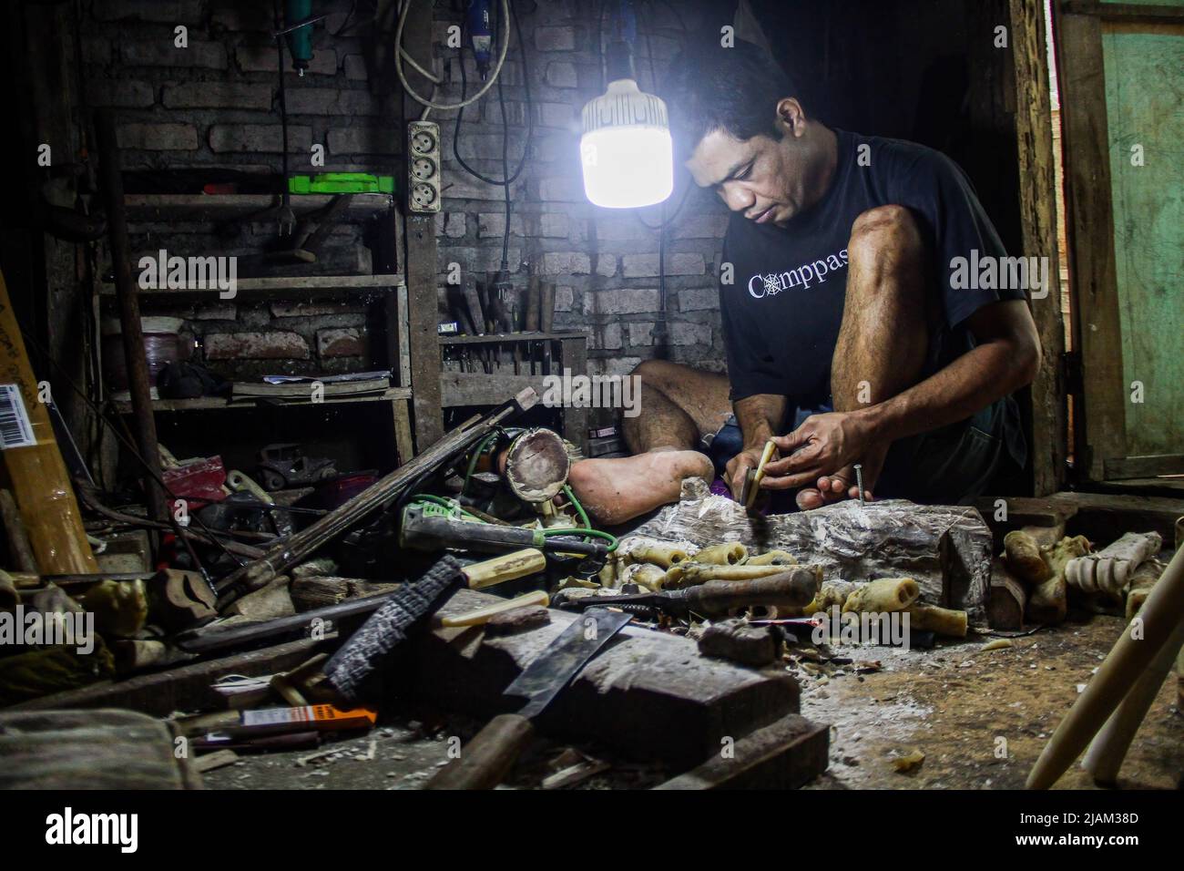 A man makes handicrafts of cigarette pipes from cow bones in Cileunyi ...