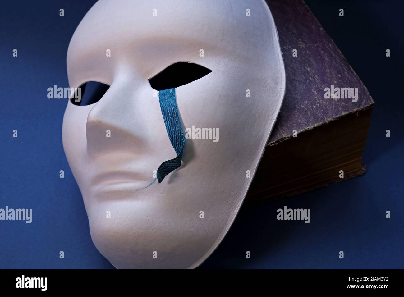 white mask and old book on blue background Stock Photo - Alamy