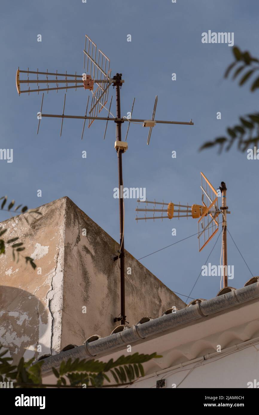 television antenna on a rooftop in front of a blue sky Stock Photo - Alamy