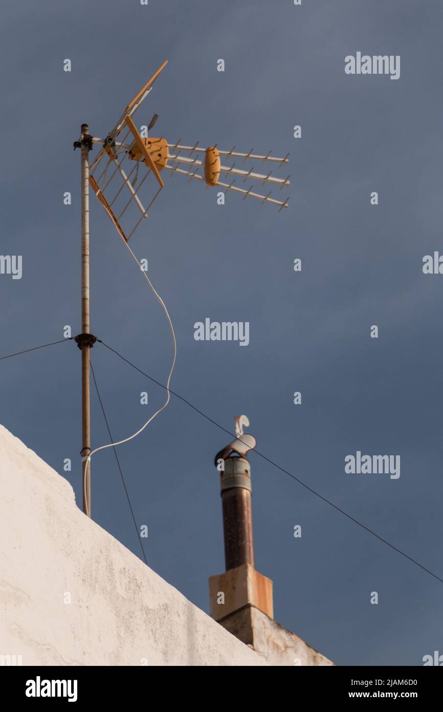television antenna on a rooftop in front of a blue sky Stock Photo - Alamy