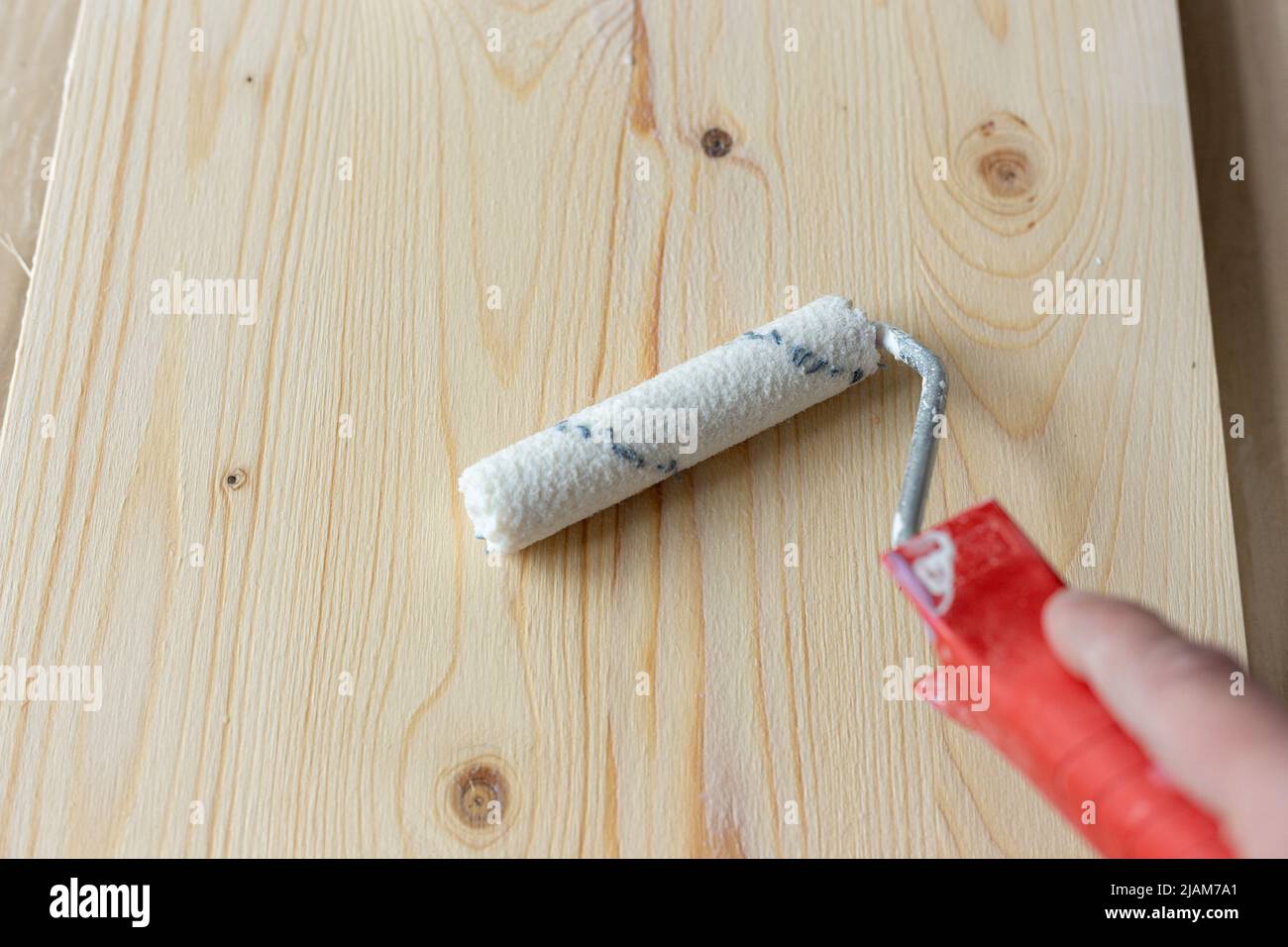 Coating the board with varnish using a roller Stock Photo - Alamy
