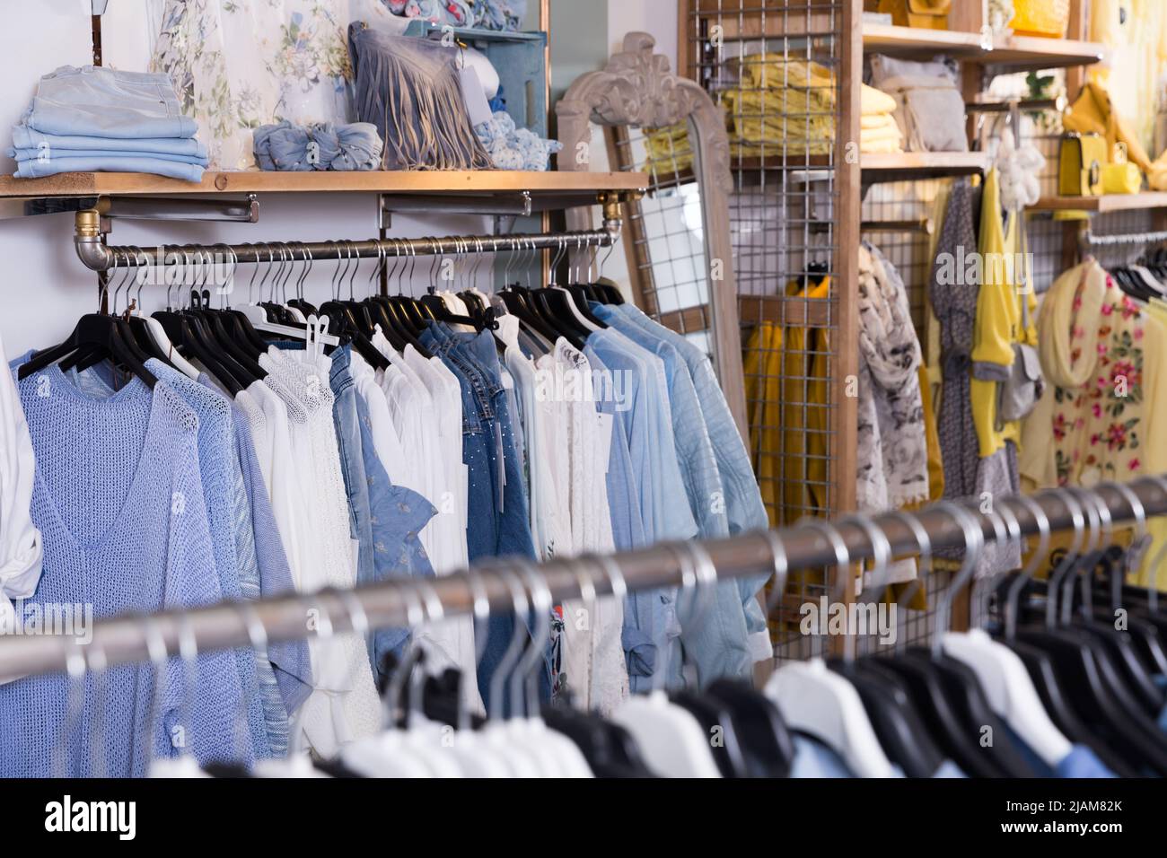 Different colored clothes in the modern shopping centre Stock Photo - Alamy