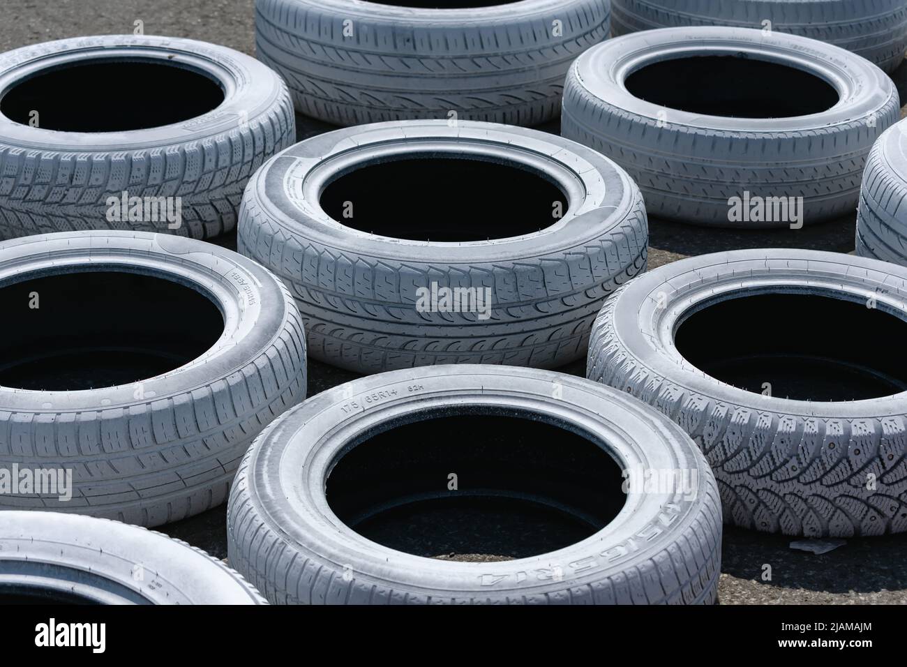 A lot of car tires lie on the road, painted white as an obstacle course ...