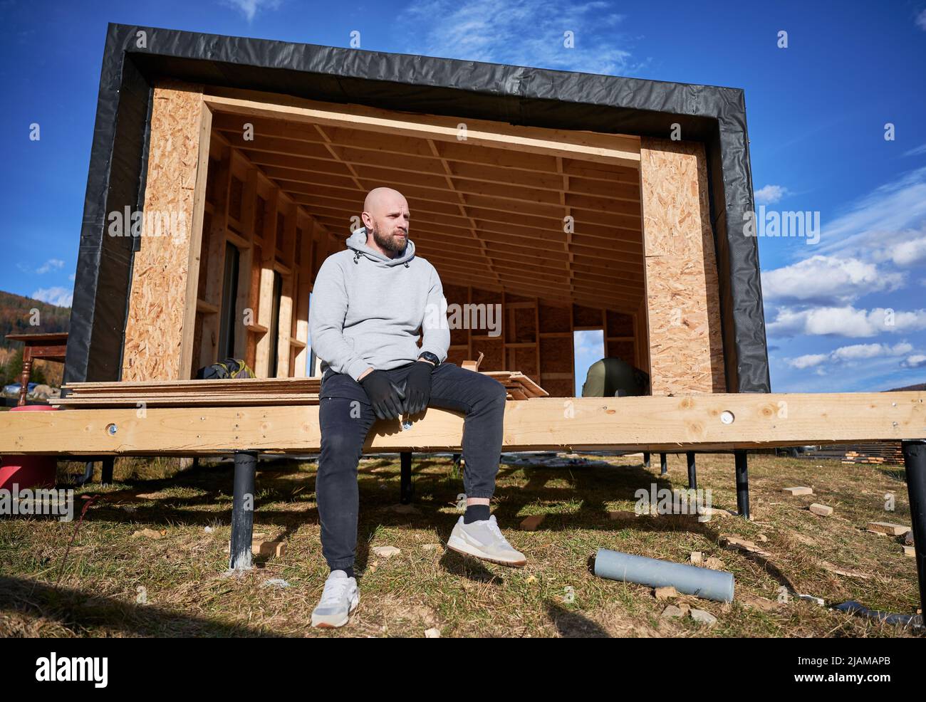 Male designer building wooden frame house on pile foundation in the Scandinavian style barnhouse ...
