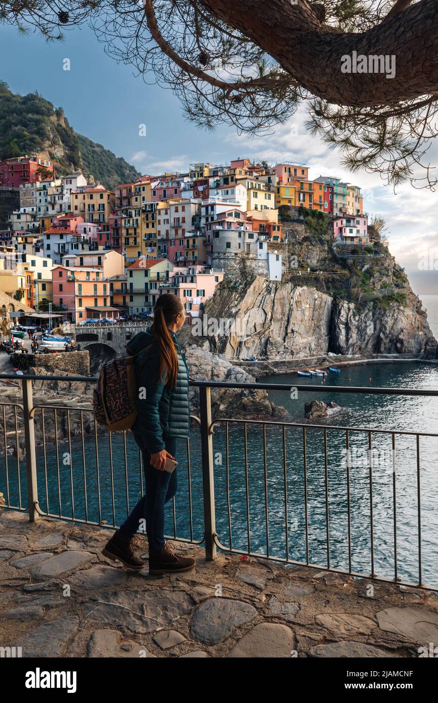 Beautiful young woman with walking along the promenade of Manarola ...