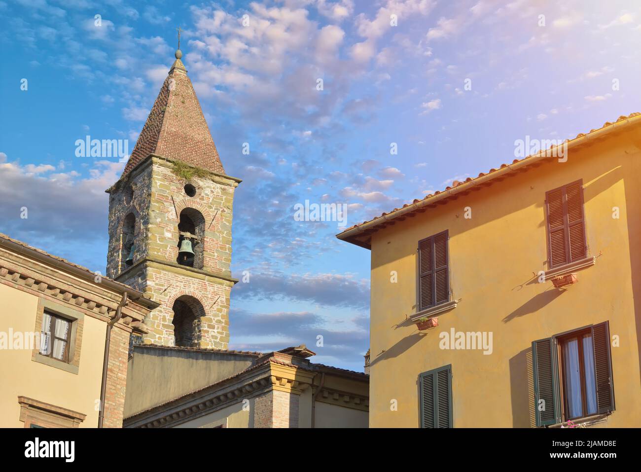 Close-up of colorful buildings, bell tower and rooftops in a blue sunny ...