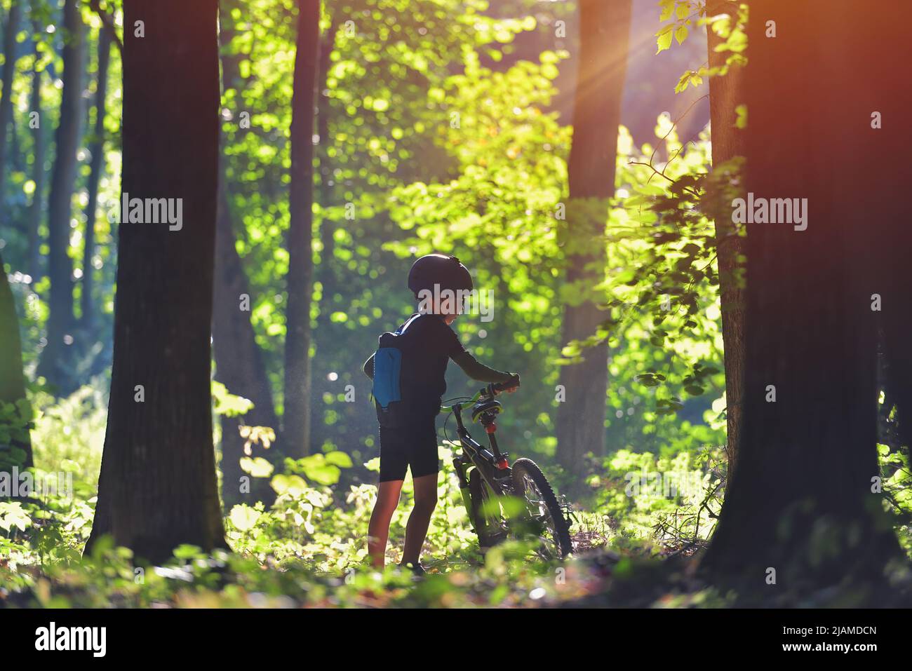 Happy kid boy of 8 years having fun in autumn park with a bicycle on ...