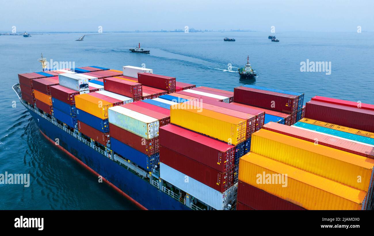 Aerial side view of cargo ship carrying container and running for ...