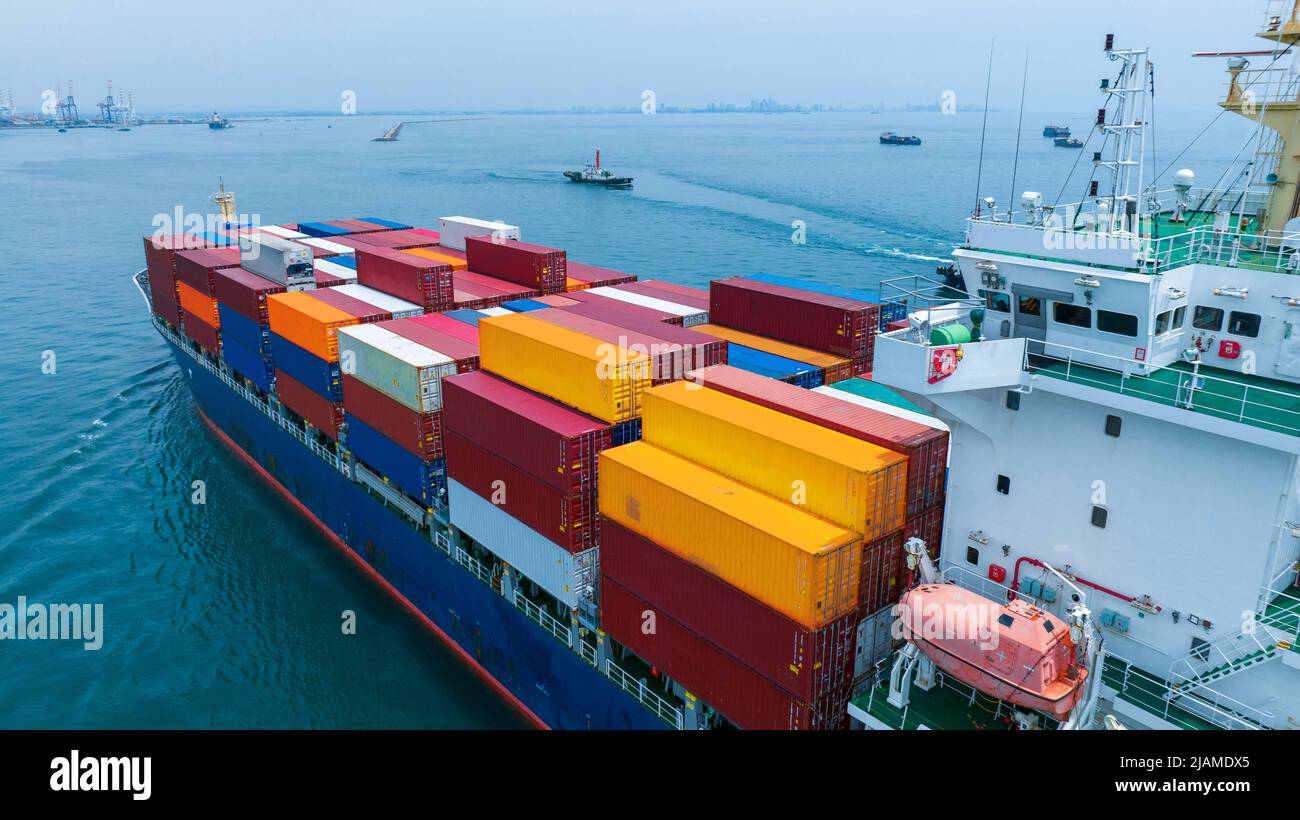 Aerial side view of cargo ship carrying container and running for ...
