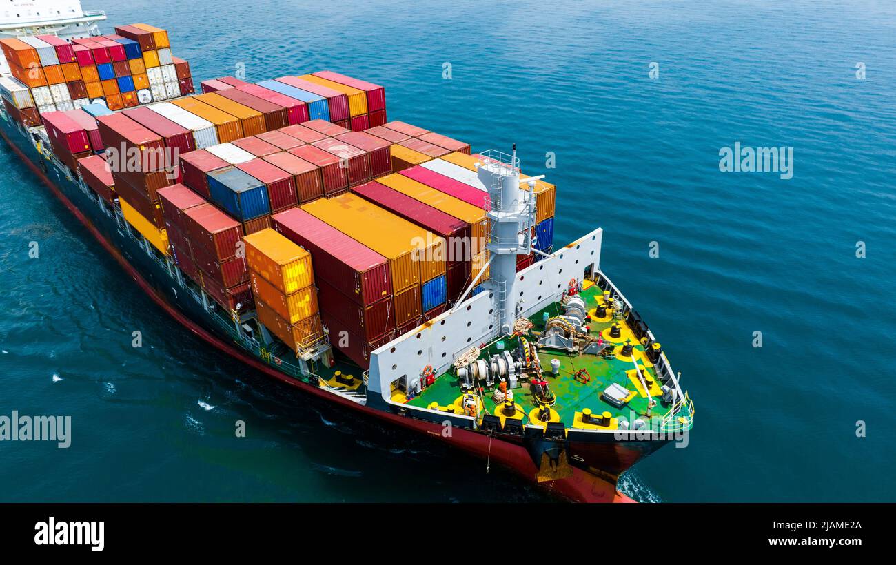 Aerial side view of cargo ship carrying container and running for ...