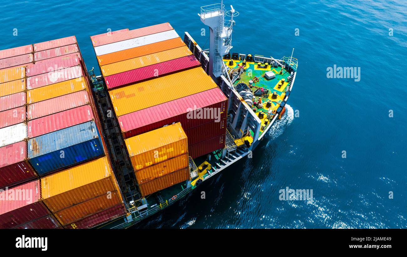 Aerial side view of cargo ship carrying container and running for ...