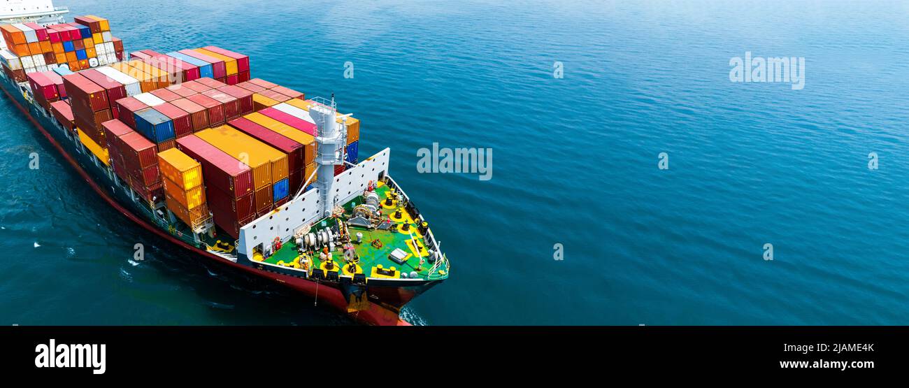 Aerial side view of cargo ship carrying container and running for ...