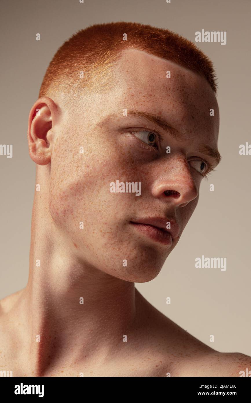 Close-up portrait of handsome young red-haired man with freckles posing ...