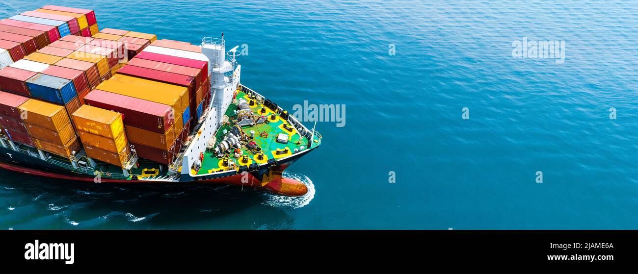 Aerial side view of cargo ship carrying container and running for ...