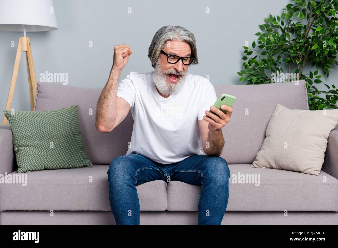 Photo of funky lucky retired man wear white t-shirt glasses sitting ...