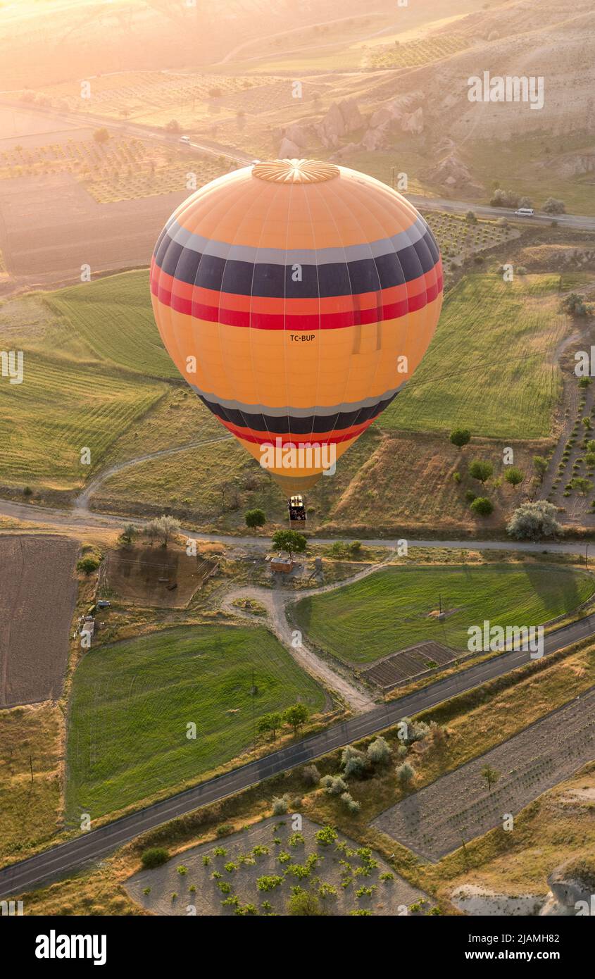 hot air balloon over agricultural fields in Cappadocia Stock Photo - Alamy