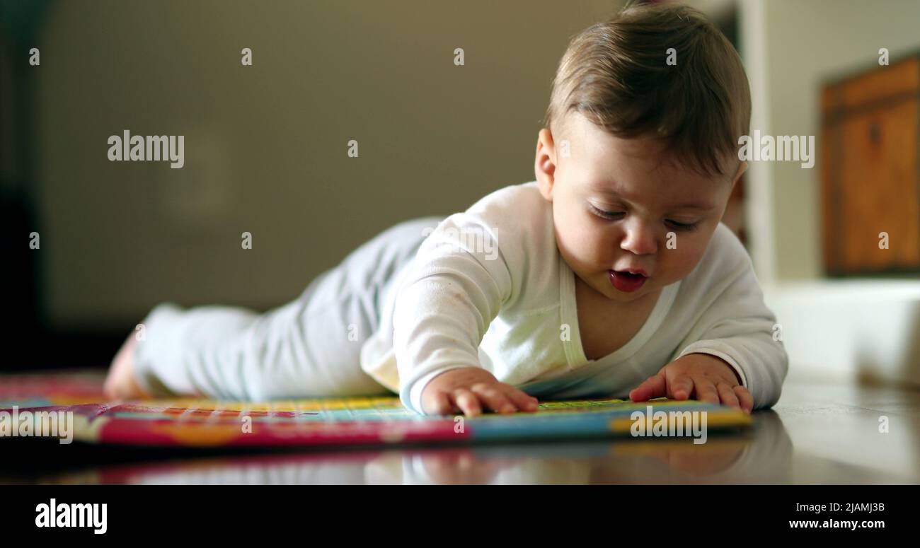 Baby learning to crawl in living-room floor. Cute toddler infant cild ...