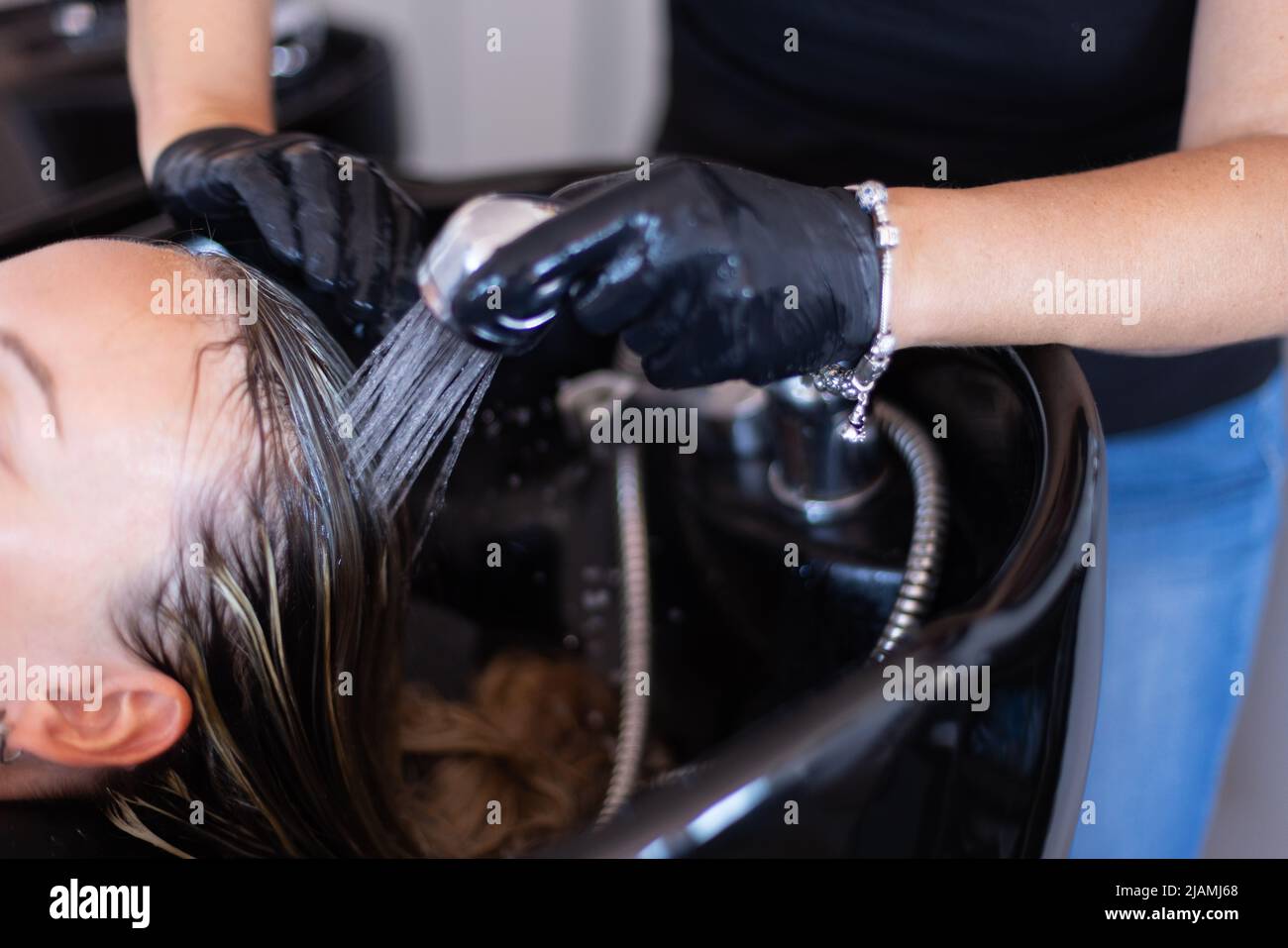 Hairdresser washing woman hair in salon. Selective focus Stock Photo ...