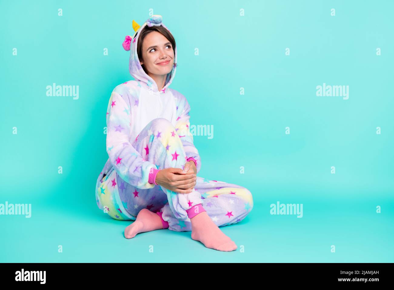 Photo of pretty sweet young lady unicorn sleepwear sitting floor ...