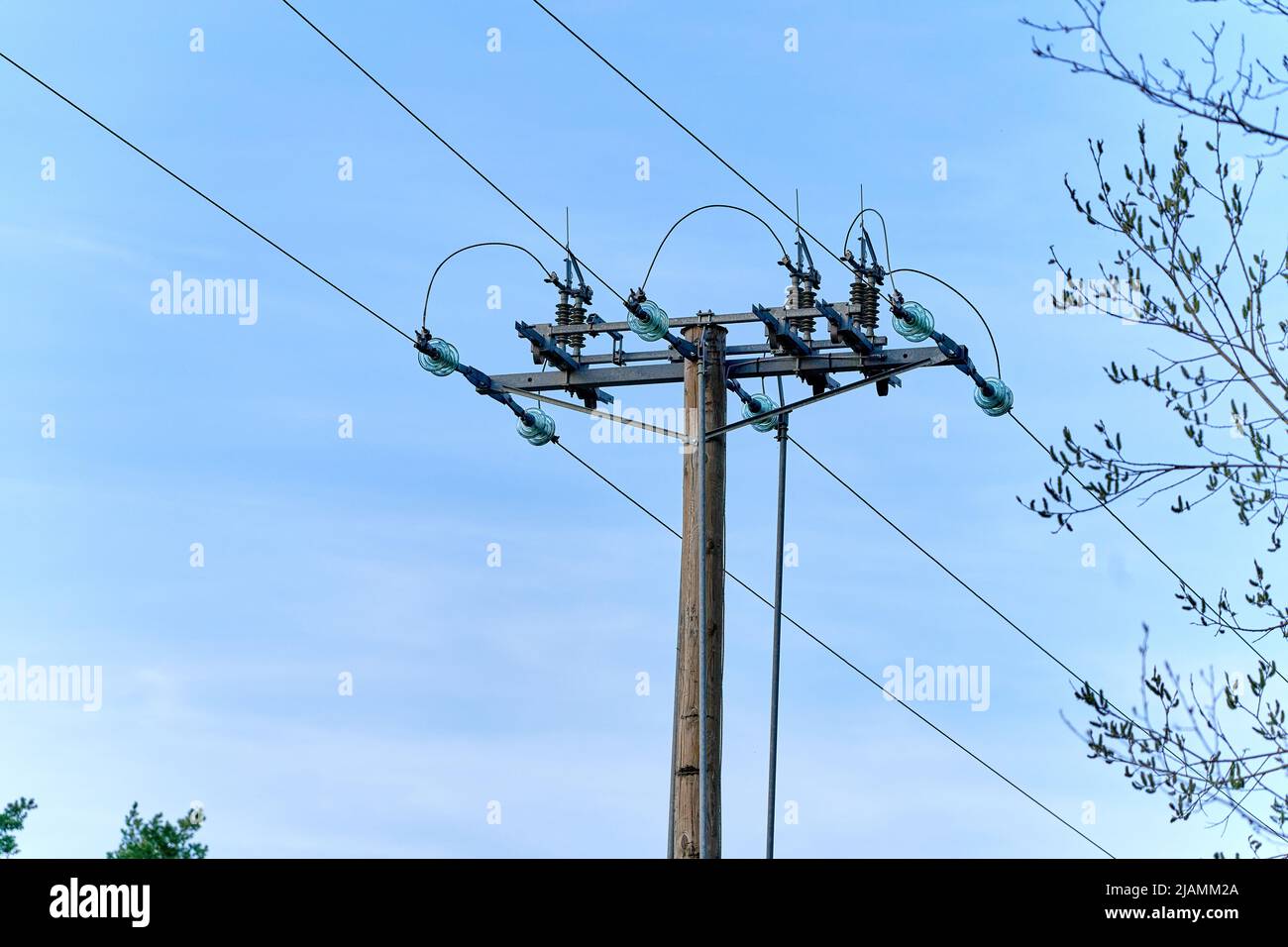 An old wooden electric pole power lines and wires with blue sky ...