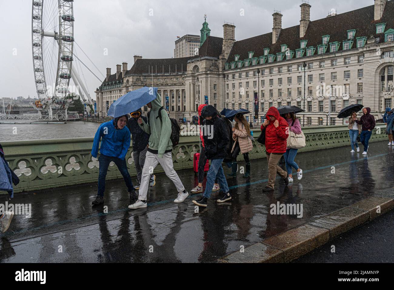 London UK, 31 May 2022. Pedestrians are caught in heavy downpours on ...